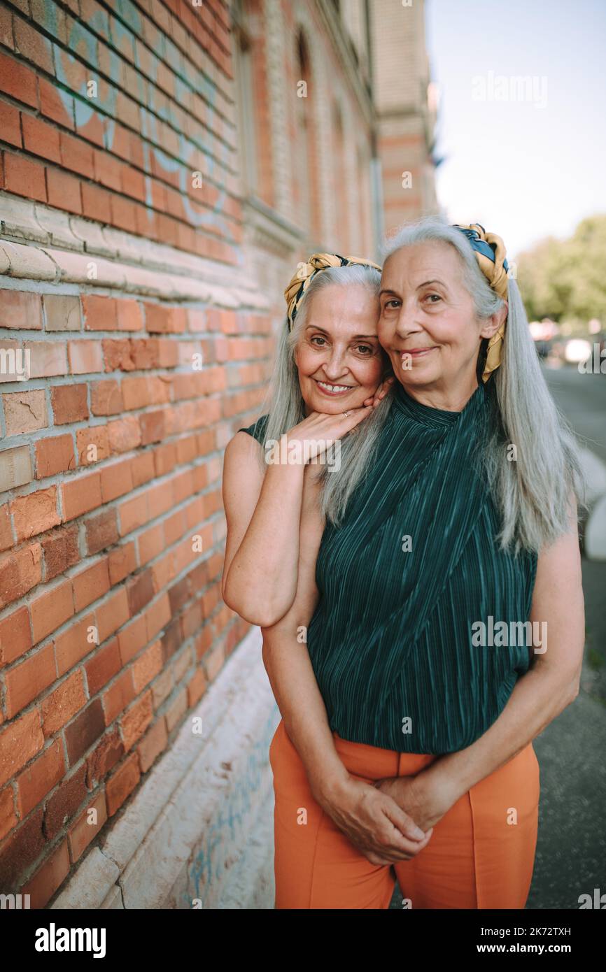 Senior women twins,in same clothes standing and posing in front of ...