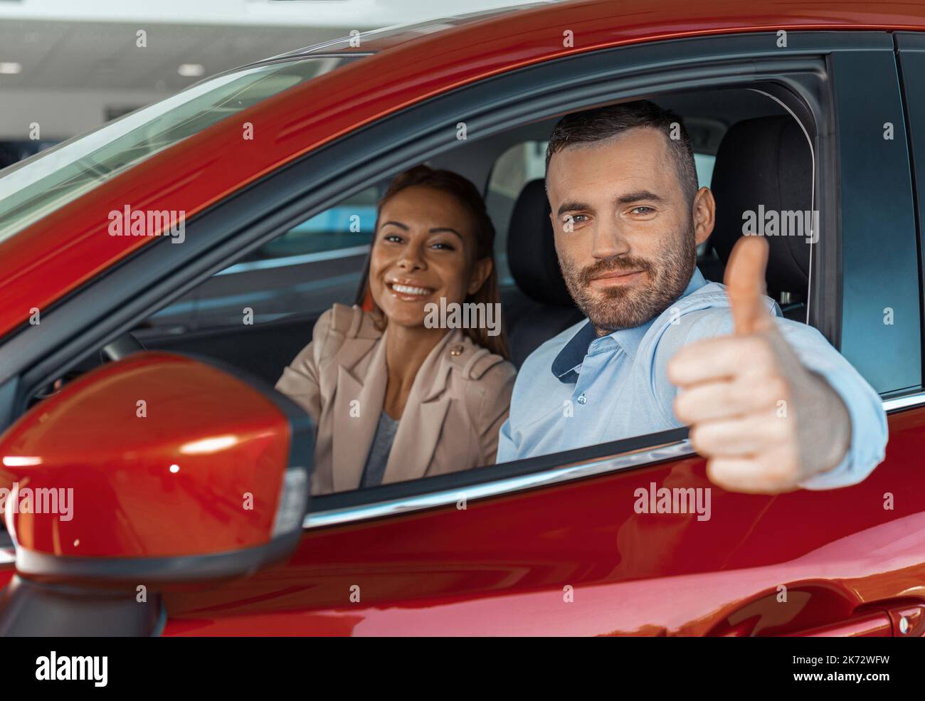 Happy young couple chooses and buying a new car for the family in the ...