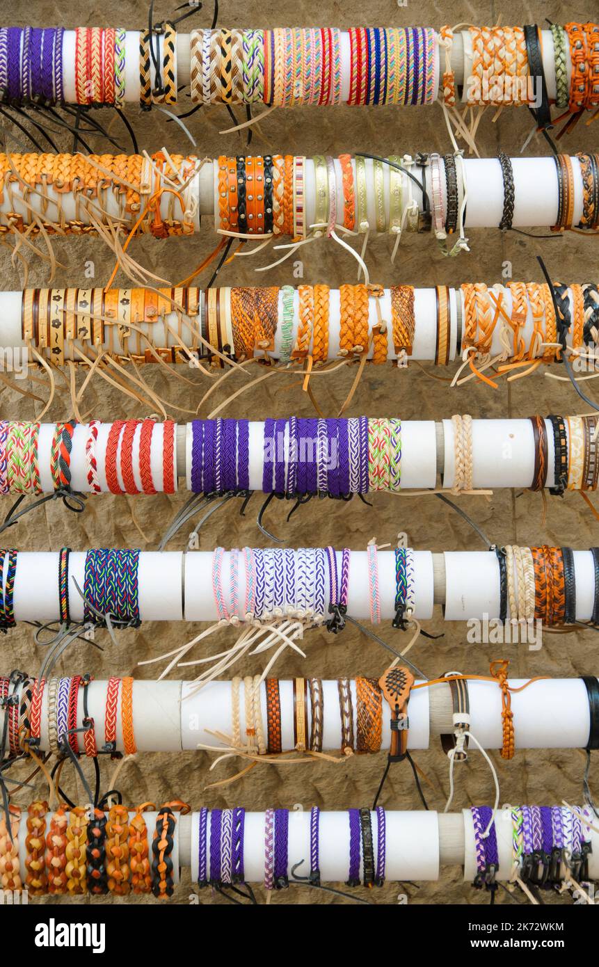 Many colorful fabric and leather bracelets on the market in detail view ...