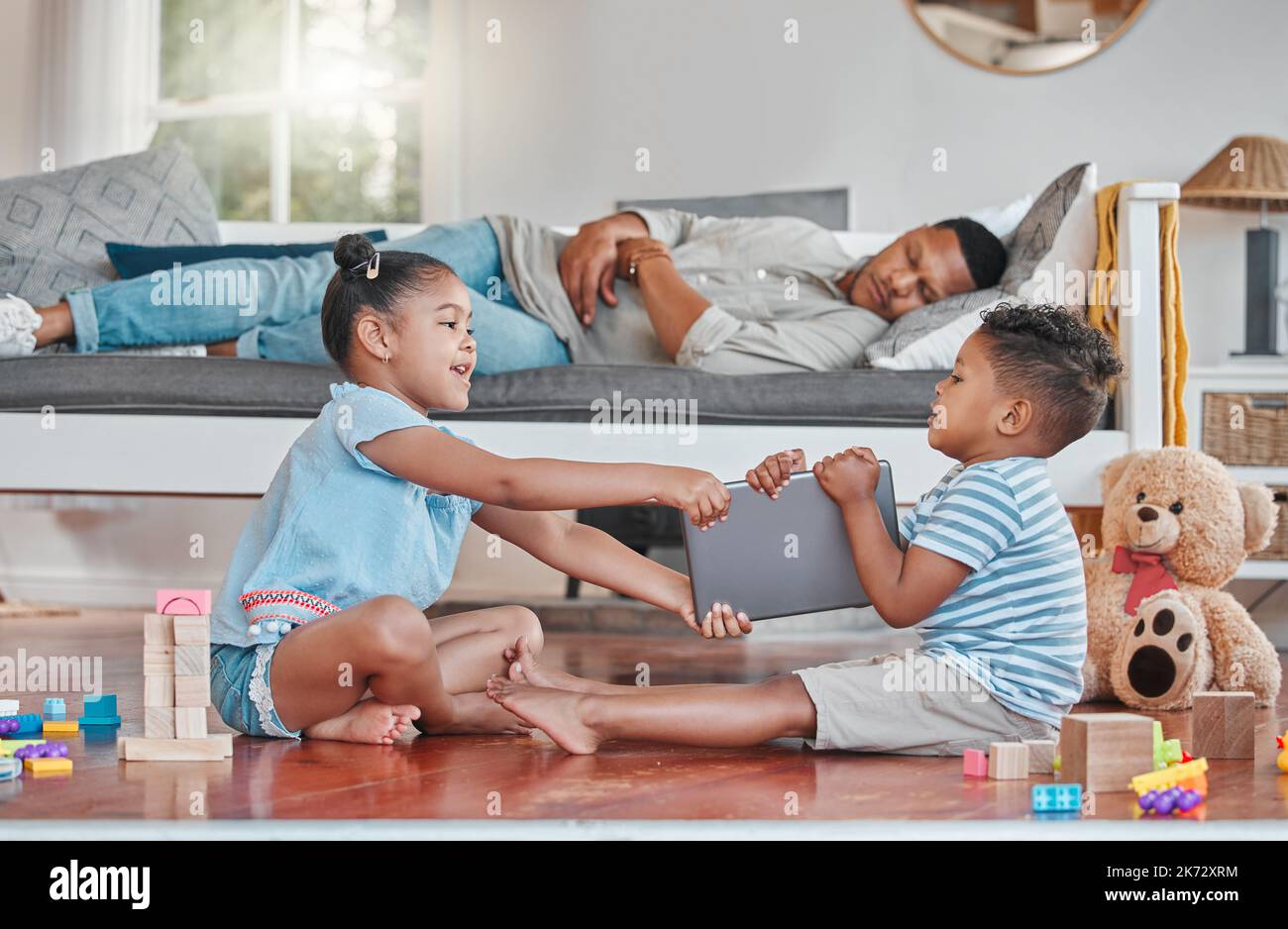 Dad says its my turn. two siblings fighting over a digital tablet on ...