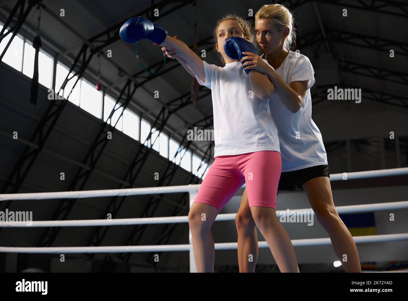 Two athletes, mother and daughter is doing sports in gym. Beginner ...