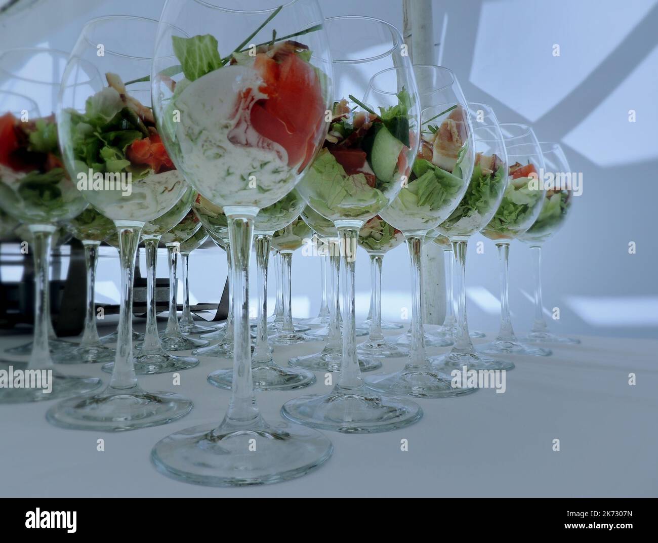 Salad cocktail with vegetable mix and white sauce in glasses on the ...