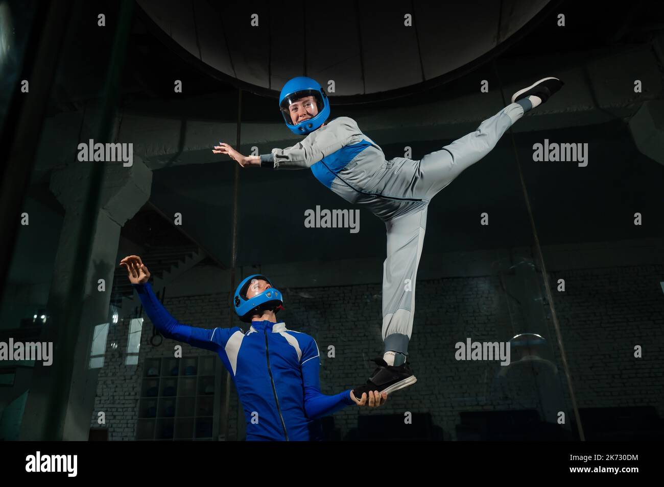 A man teaches a woman how to fly in a wind tunnel. Free fall simulator ...