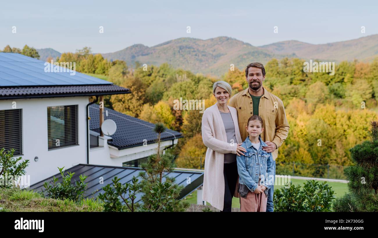 Happy family near their house with solar panels. Alternative energy ...