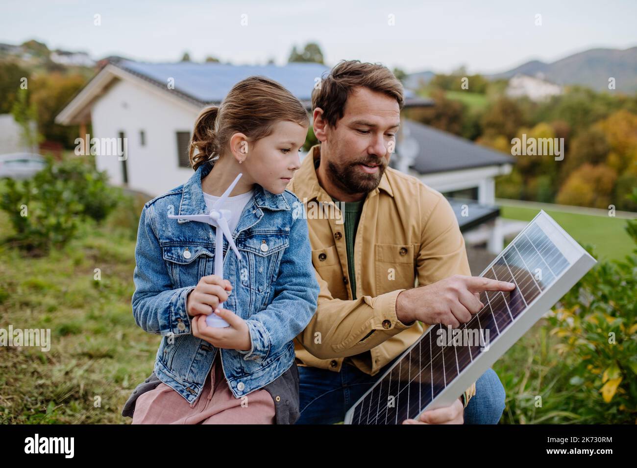 Father showing his little daughter solar photovoltaics panels ...