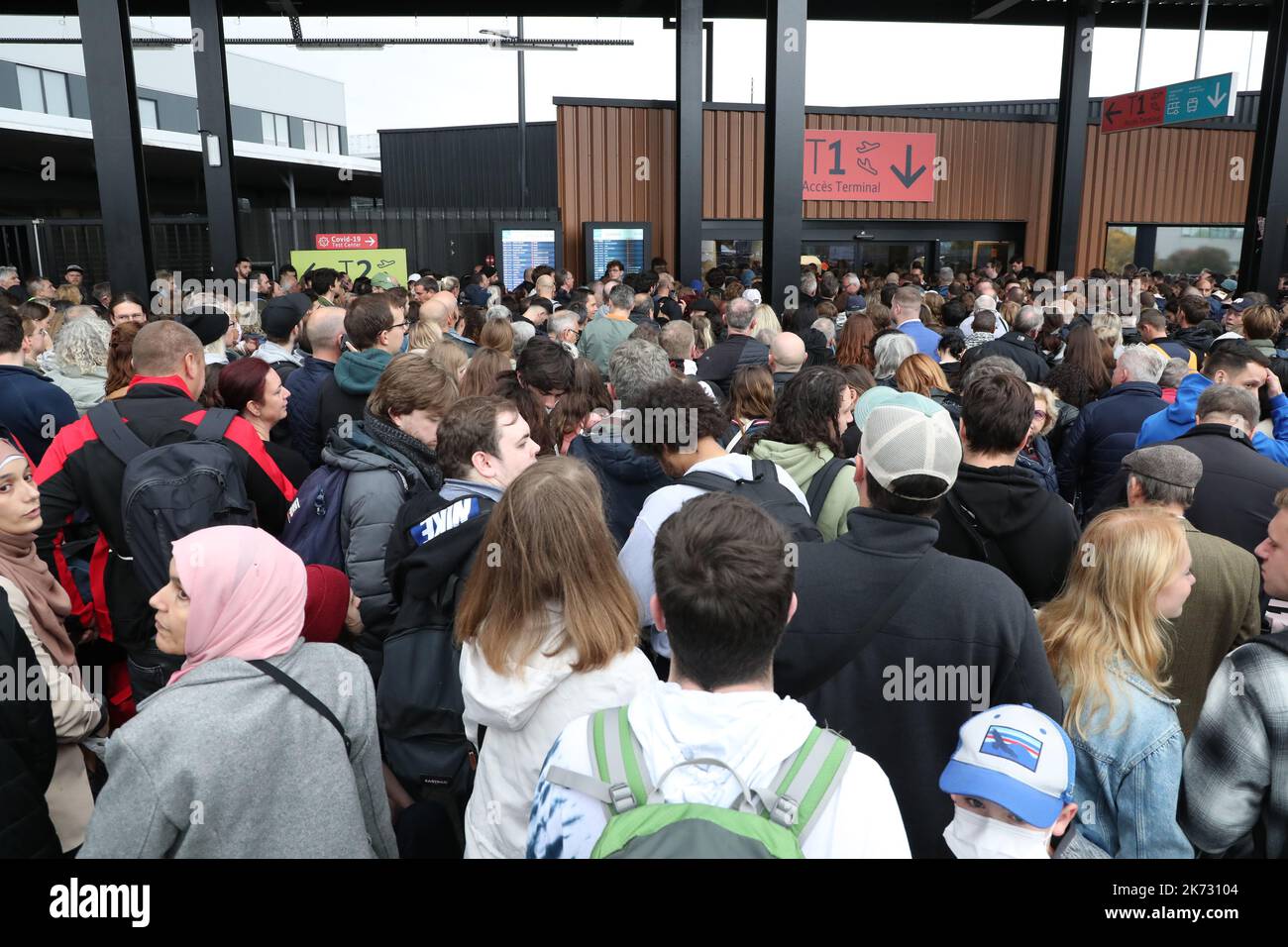 Passengers queue outside their terminal during a strike action of the ...