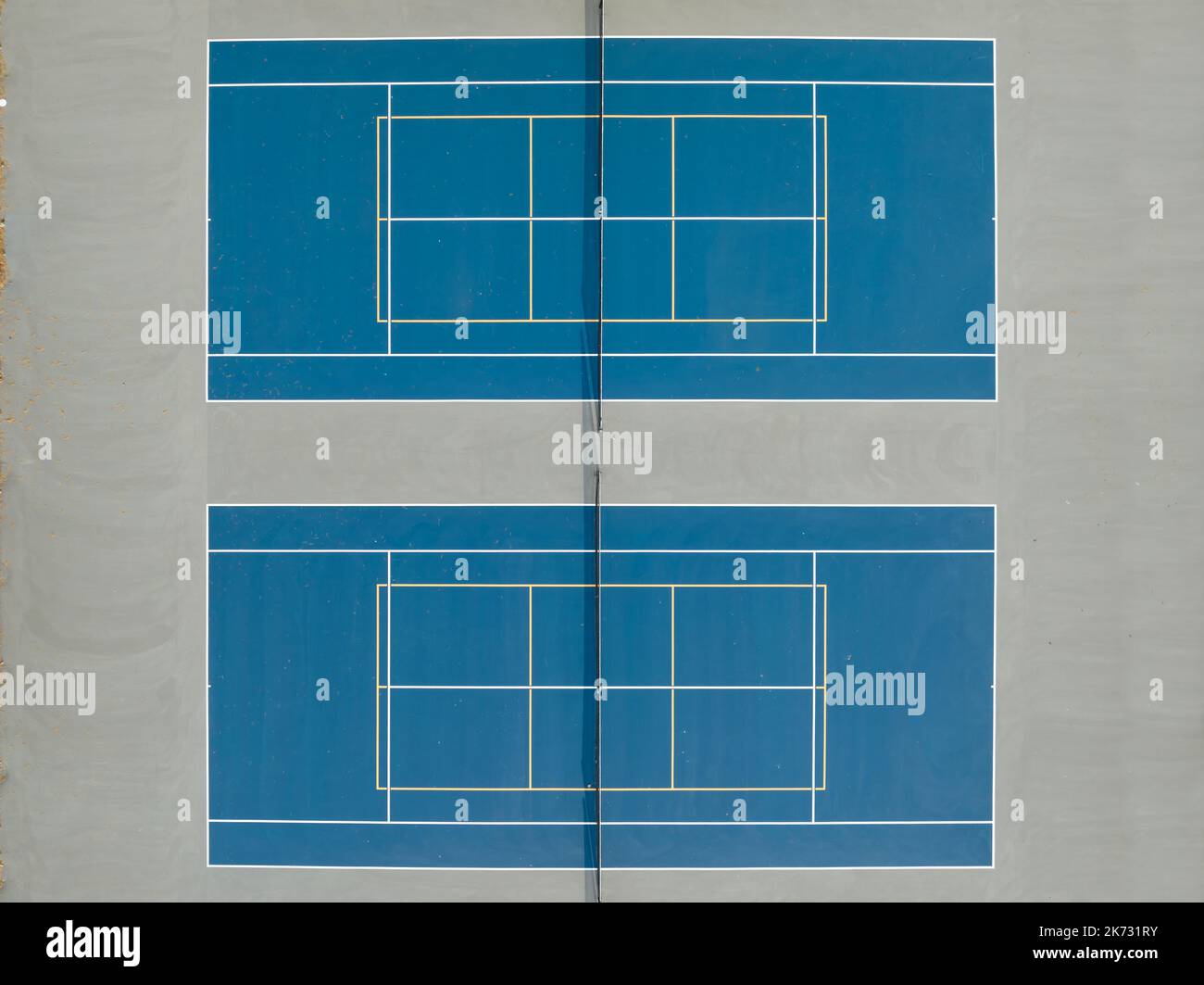 Aerial photo of outdoor blue tennis courts with yellow pickleball lines ...