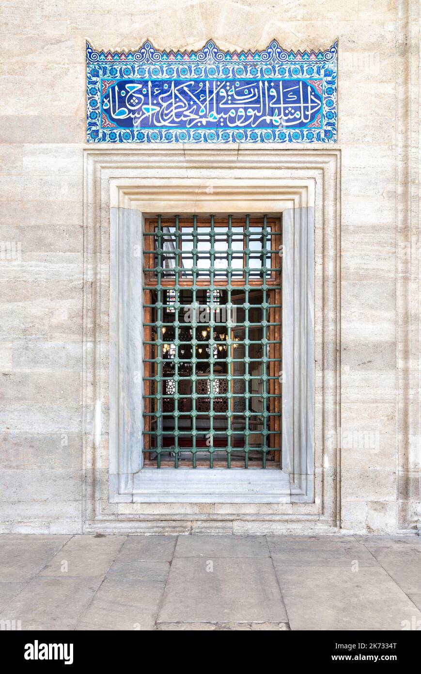 Decorated wrought iron window, in a stone wall, at the courtyard of ...