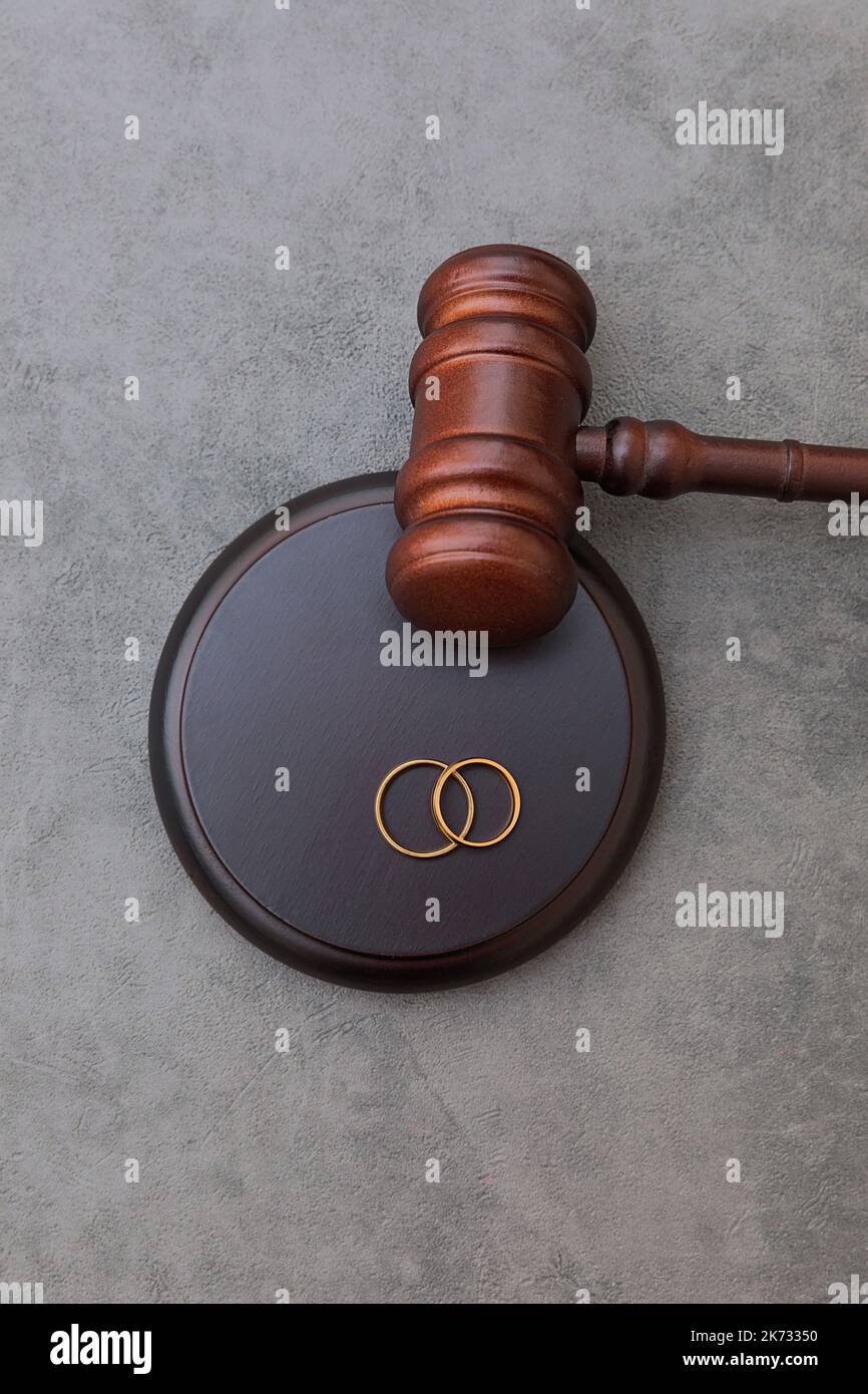 Law theme. Judge gavel wedding rings on concrete stone grey background ...