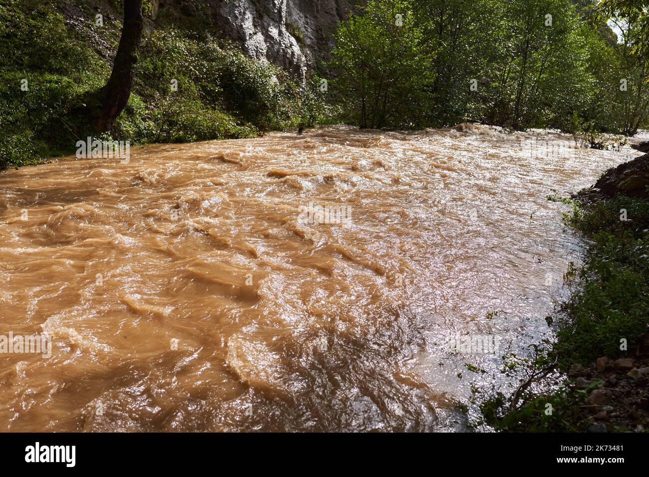 River flooding with muddy waters making rapids and waves Stock Photo ...