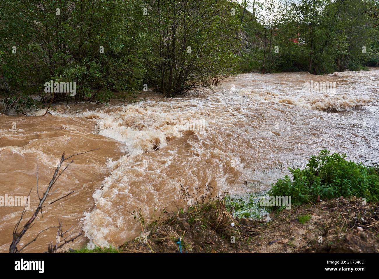 River flooding with muddy waters making rapids and waves Stock Photo ...