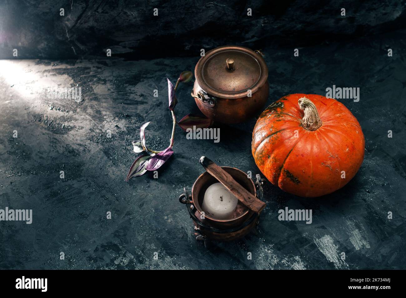 One pumpkin squash and copper or brass witch pots with candles and palo ...