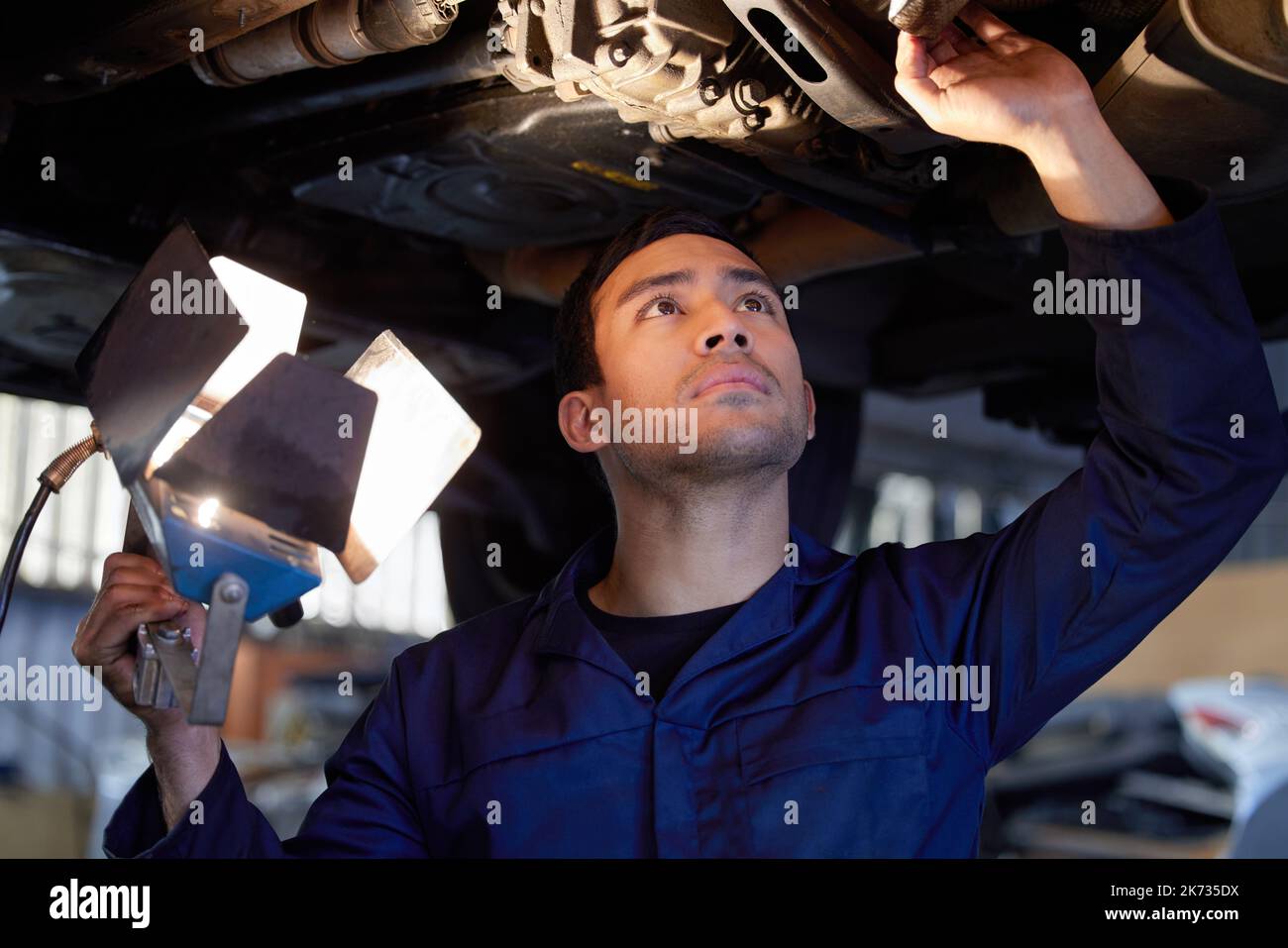 Locating the problem. a handsome young male mechanic working on the ...