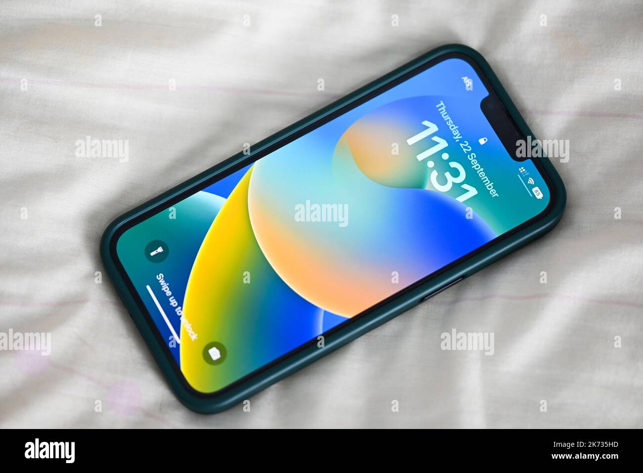 iPhone with iOS 16 logo on home screen, close up new operating system ...