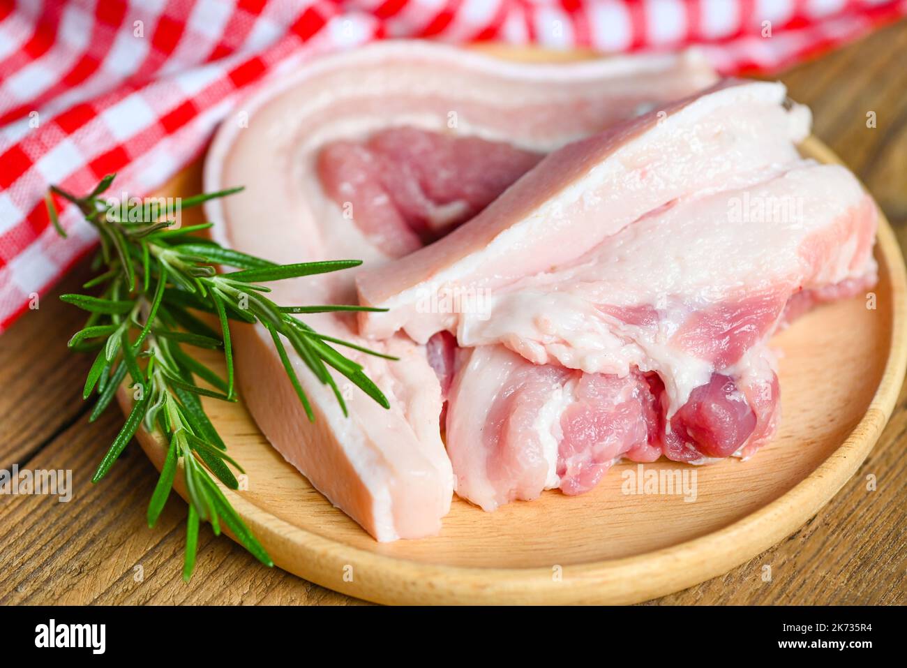 pork on wooden plate with rosemary, fresh raw streaky pork meat for ...