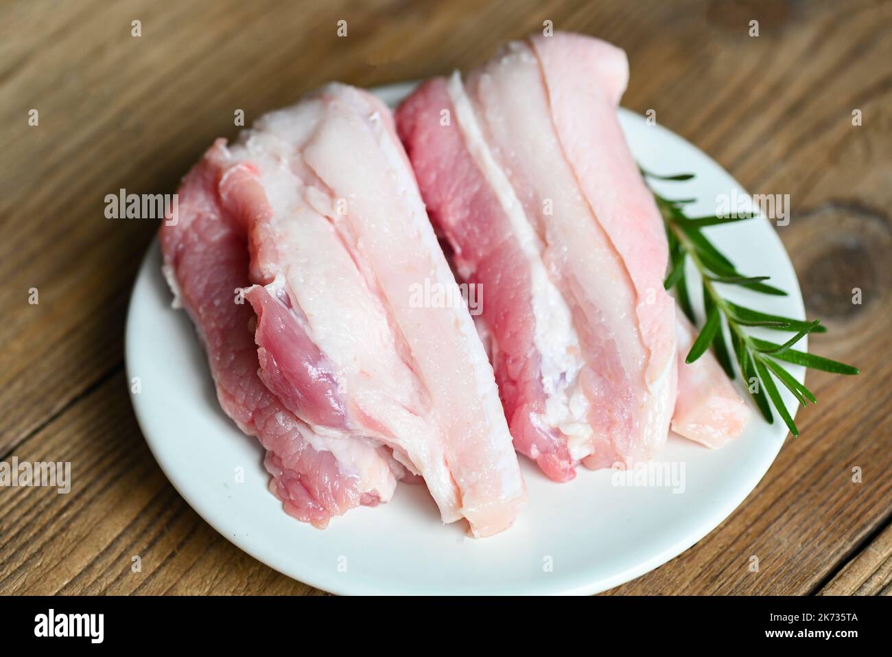 pork on wooden plate with rosemary, fresh raw streaky pork meat for ...