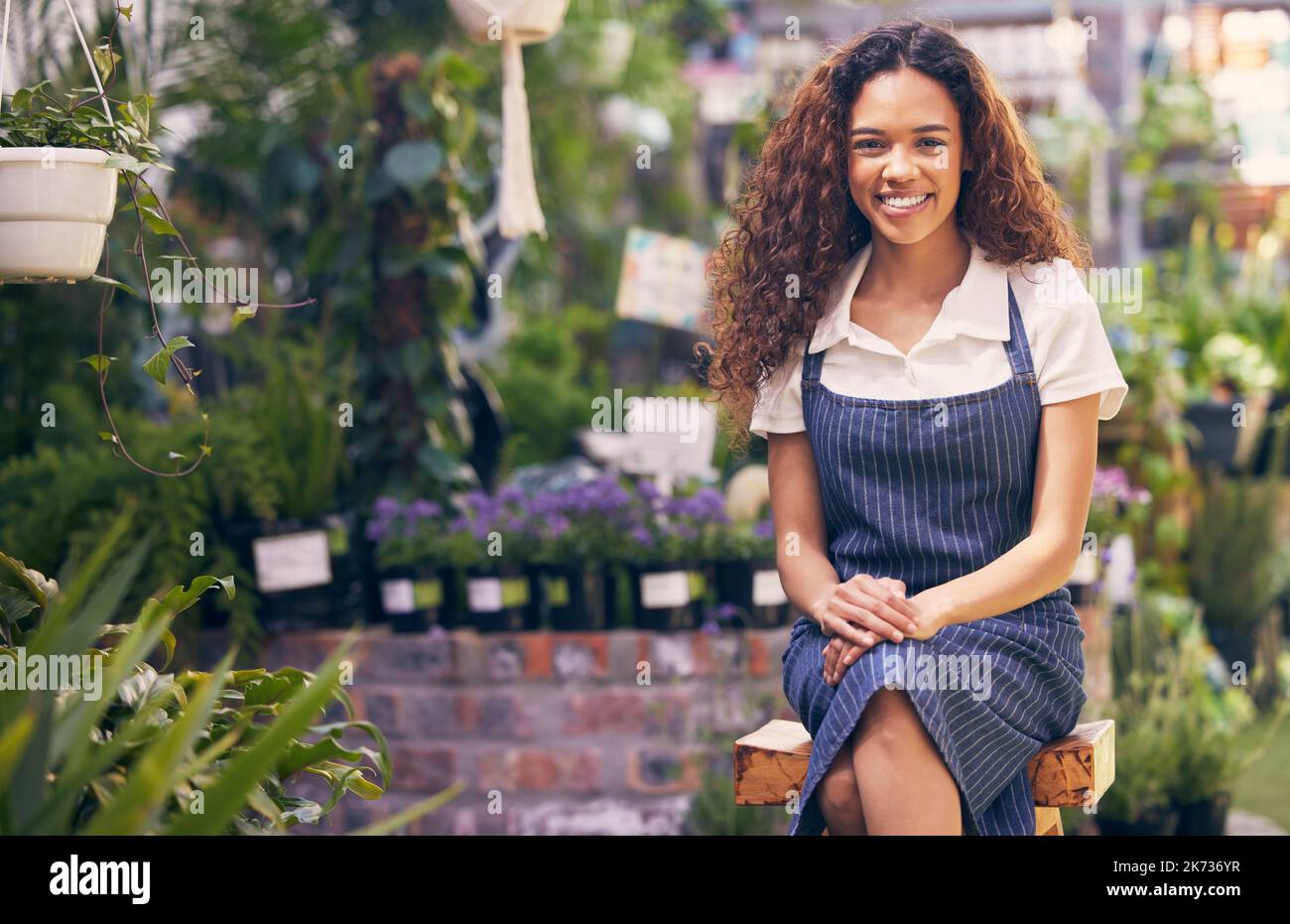Proud of my success. a beautiful young florist sitting in her garden ...