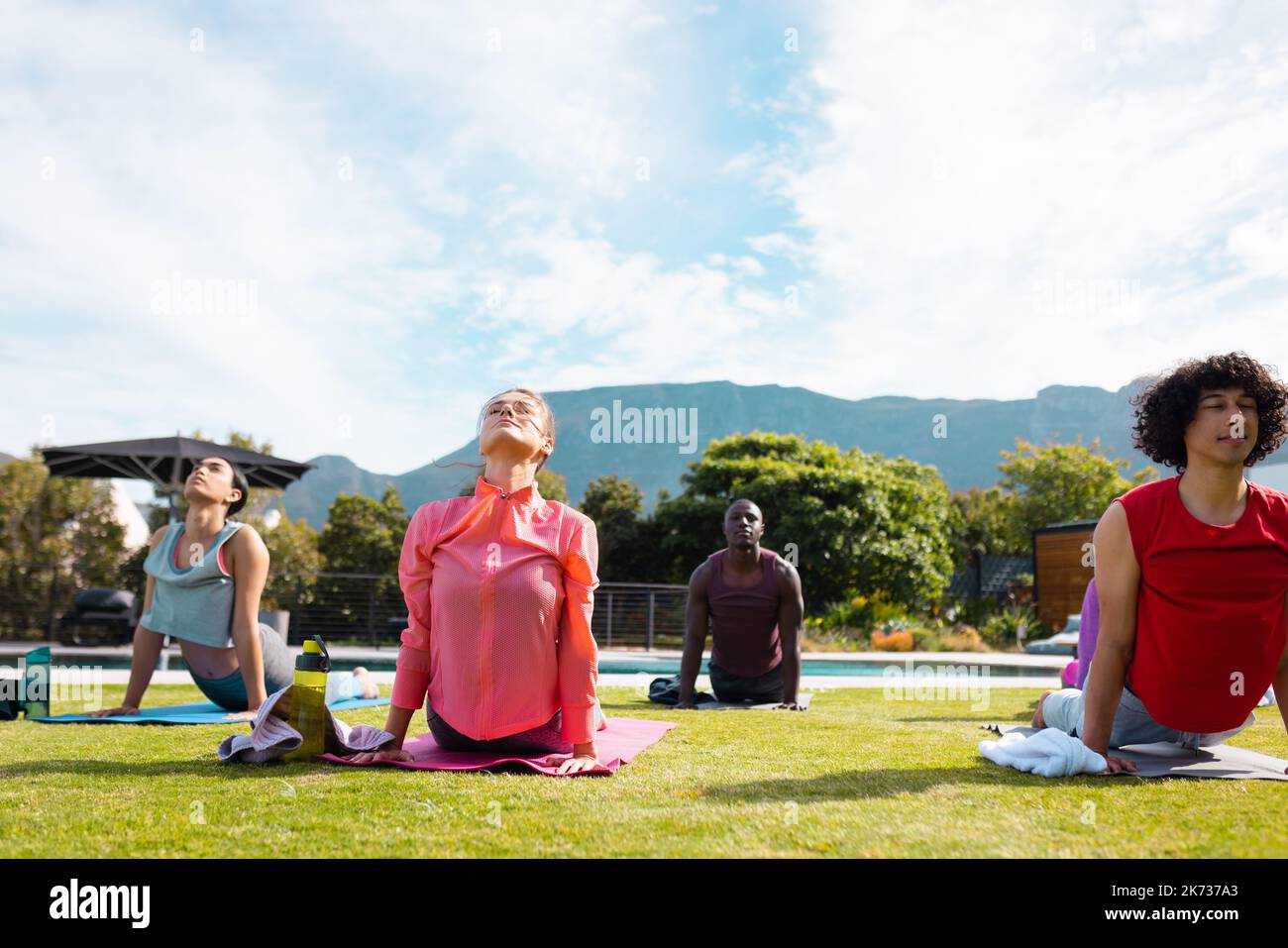 Diverse friends practicing yoga and stretching in garden Stock Photo ...