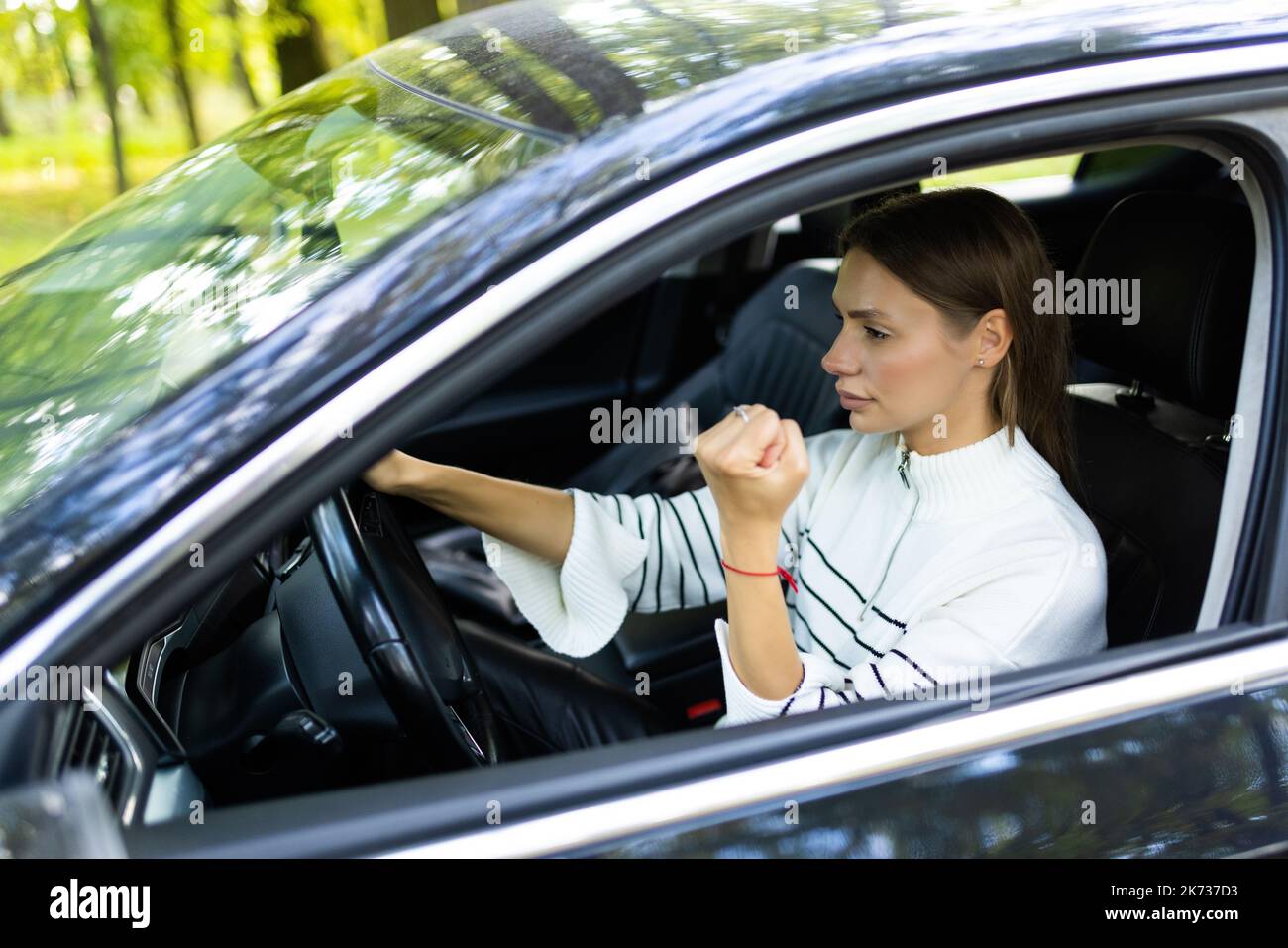Closeup photo of angry driver showing her fist and screaming ...