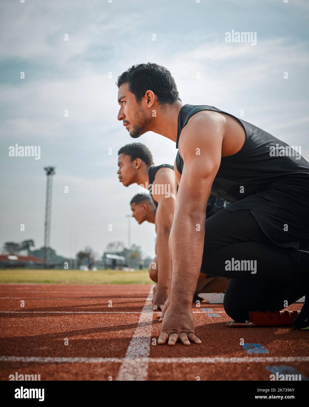 Ready for a run. three handsome young male athletes starting their race ...