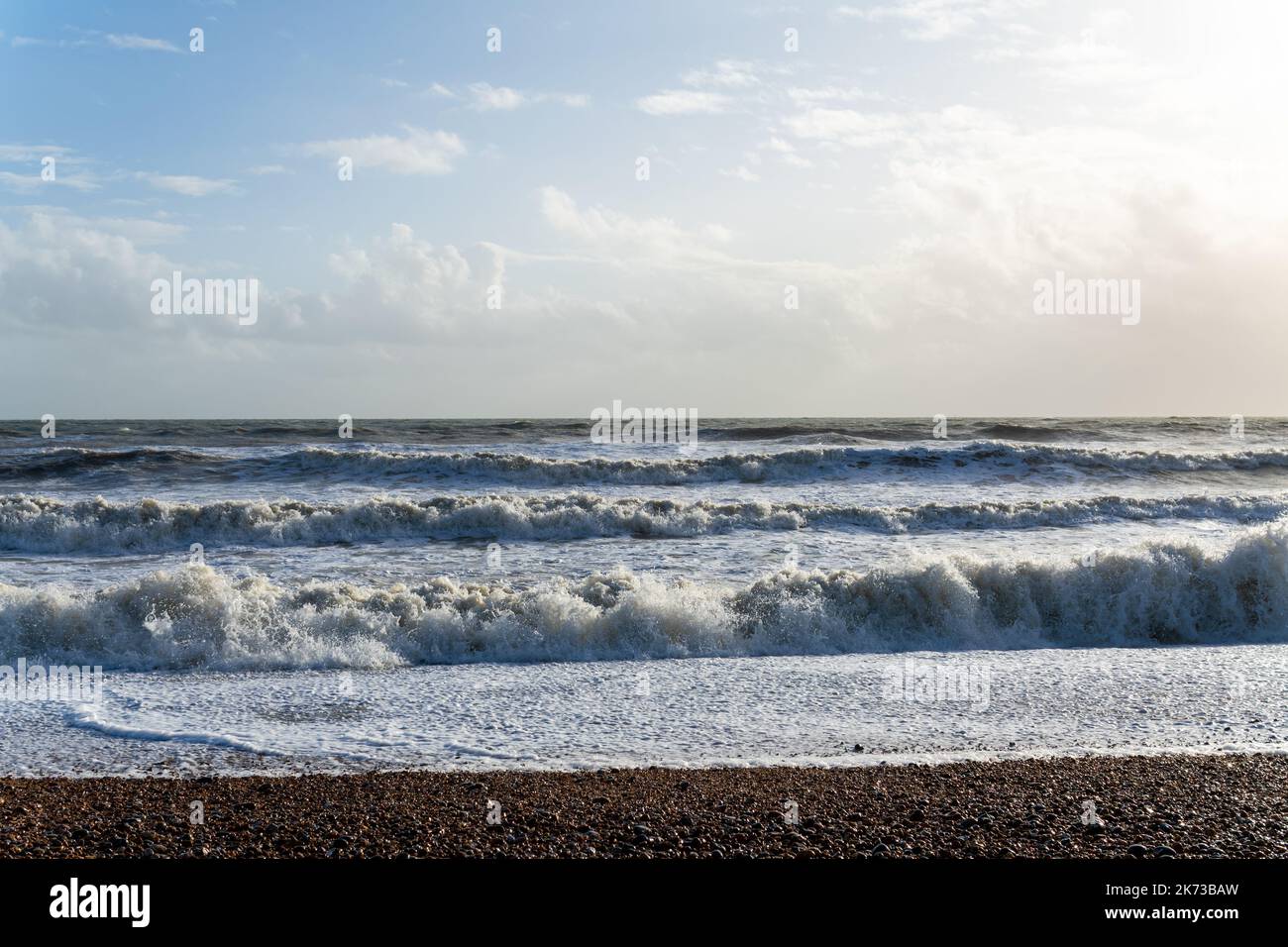 Waves breaking on Bexhill beach in late afternoon sun in November Stock ...