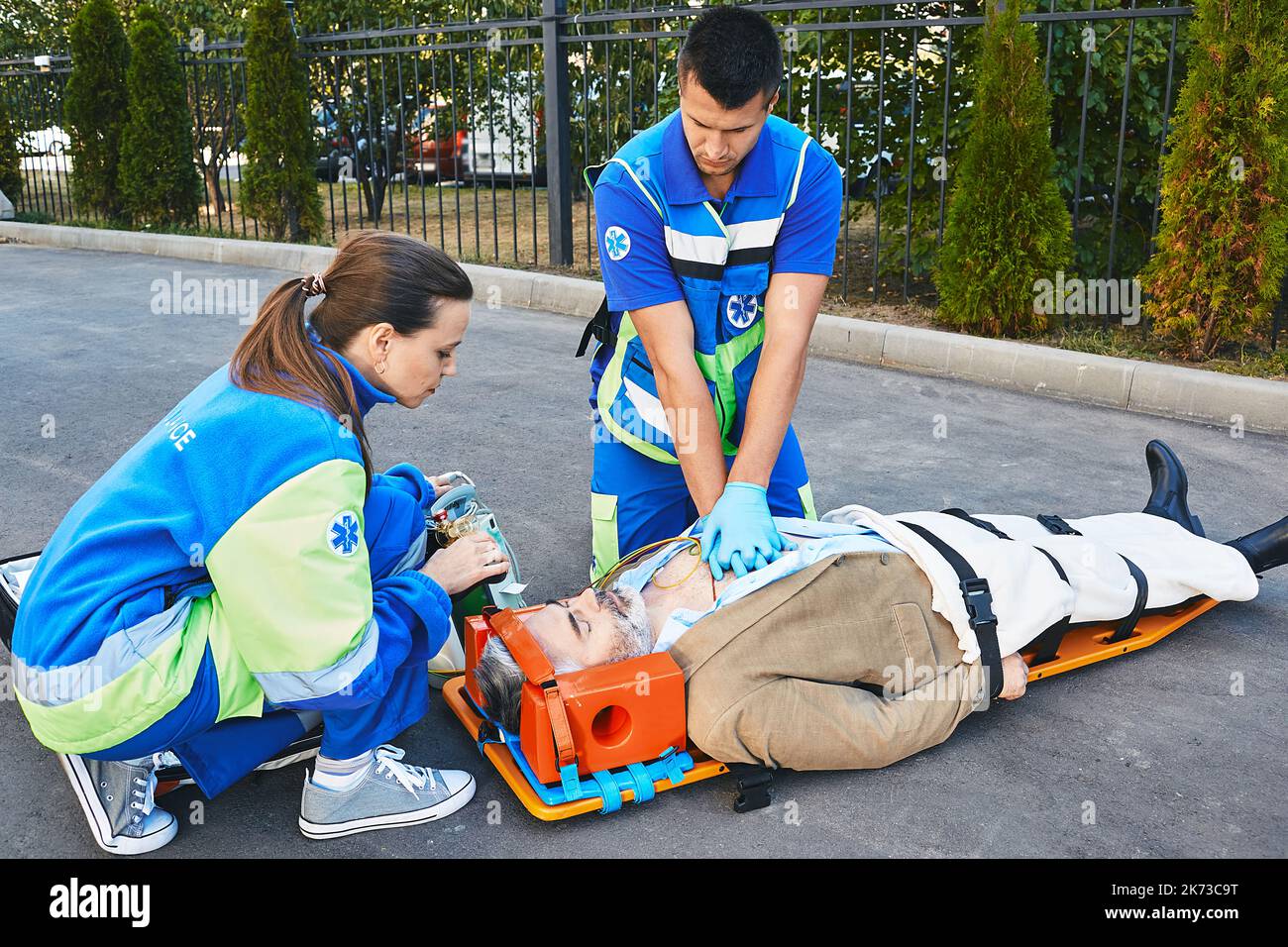 Personnel of emergency service provide first aid to victim with medical equipment, give heart ...