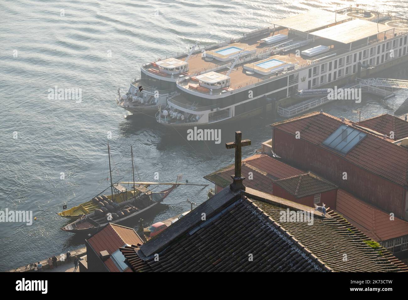 View from above looking down past a church spire towards two barges on ...