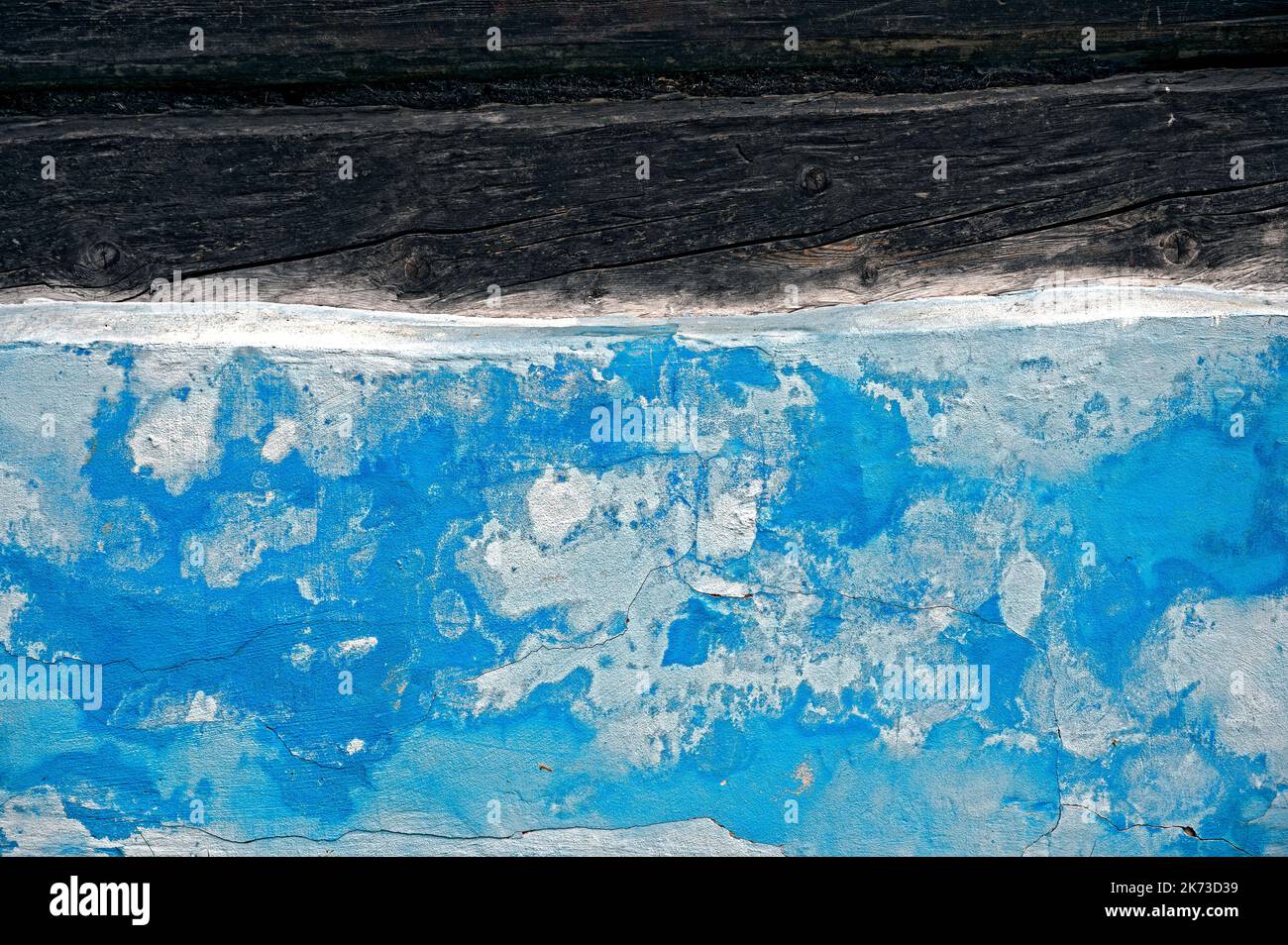 traditional blue painted basement of an old wooden building with cracks ...