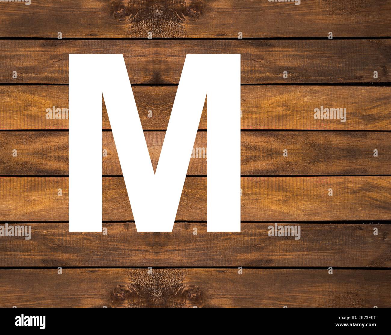 M capital letter of alphabet in white hole on wood background Stock ...