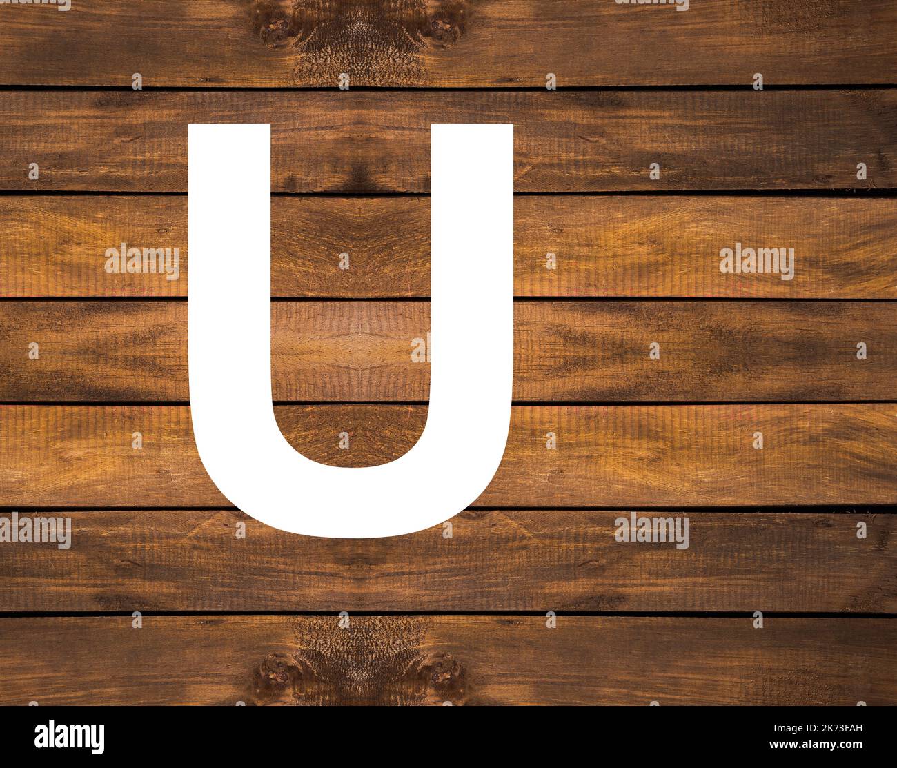 U capital letter of alphabet in white hole on wood background Stock ...