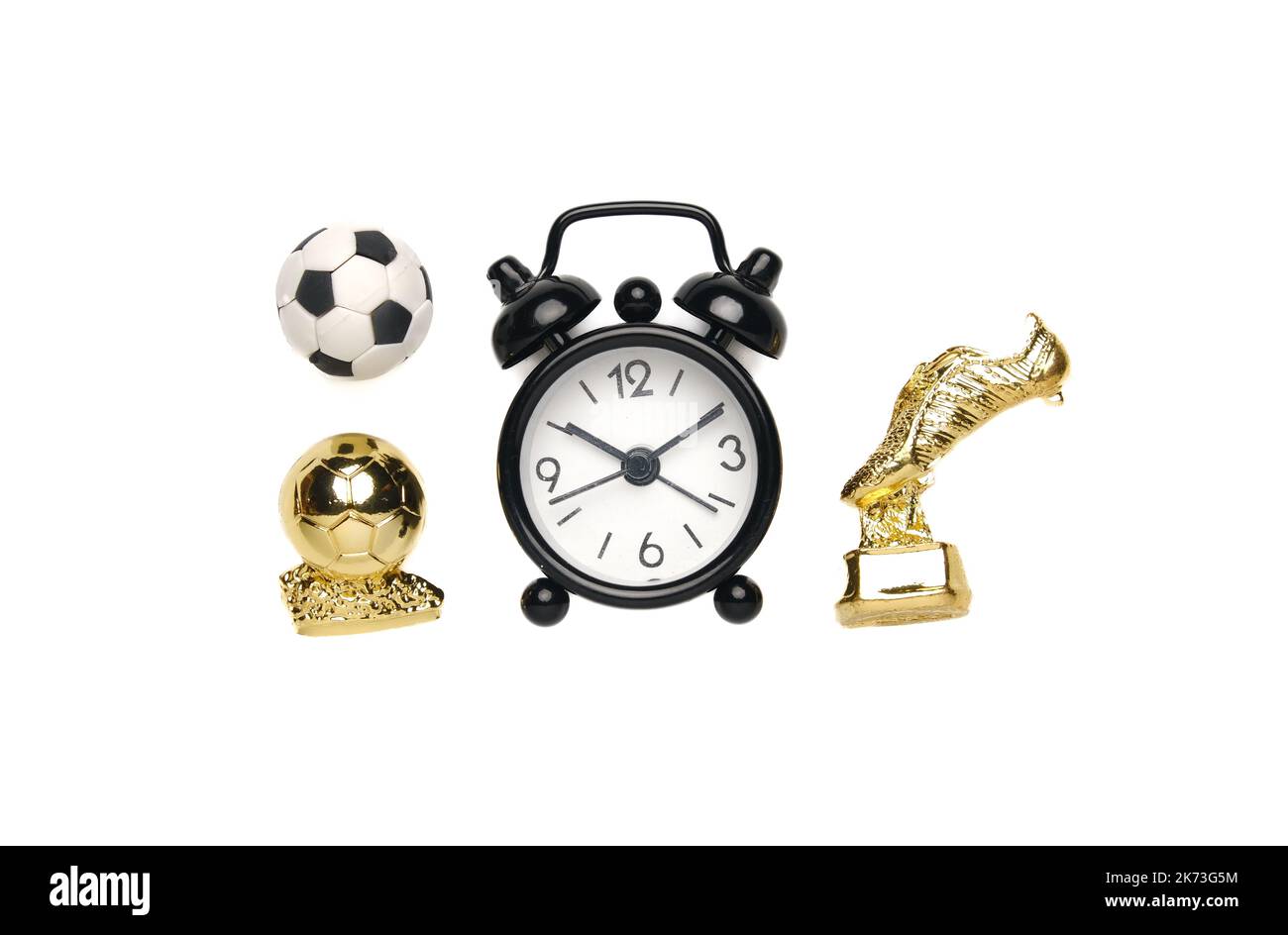 A flatlay picture of alarm clock, ball, golden ball and golden boot on ...