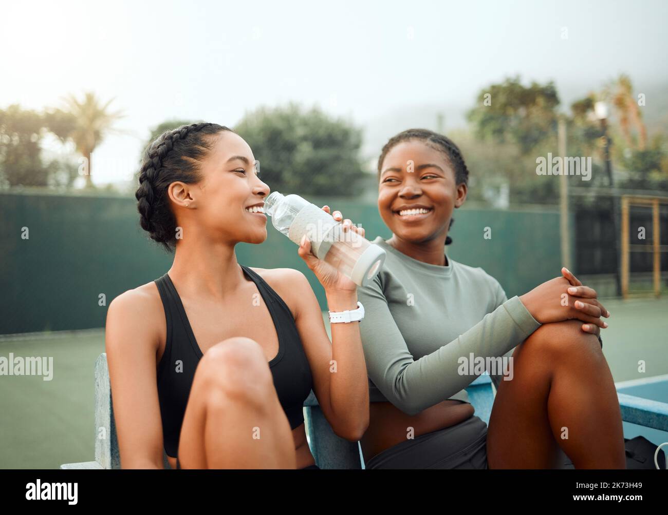 Staying hydrated between sets. two attractive young female athletes ...