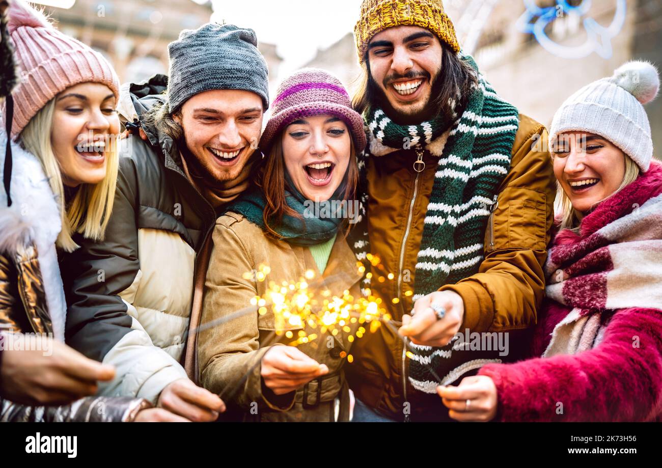 Guys and girls best friends cheering with sparklers on warm fashion ...