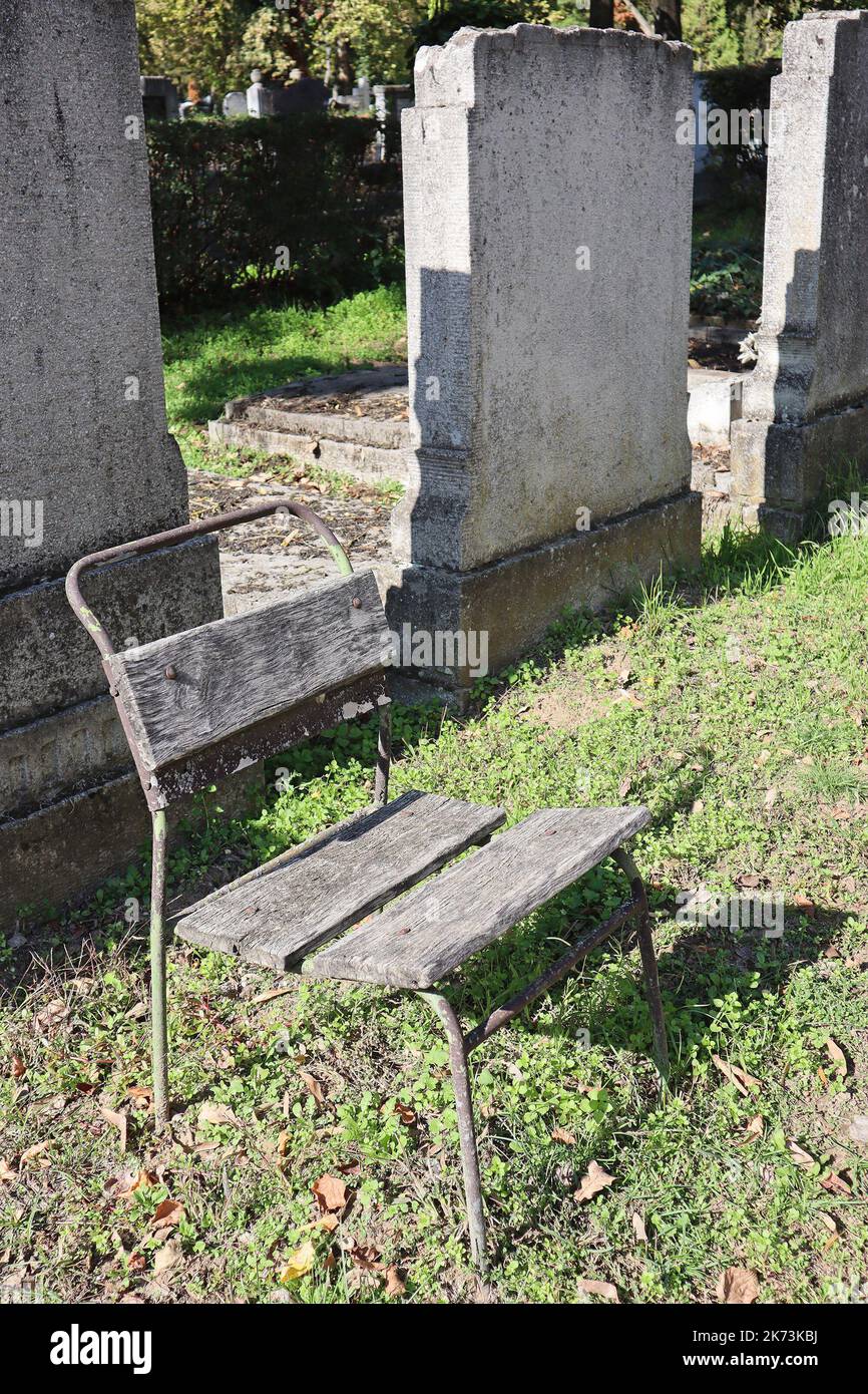 Old wooden park bench in the public cemetery Stock Photo - Alamy