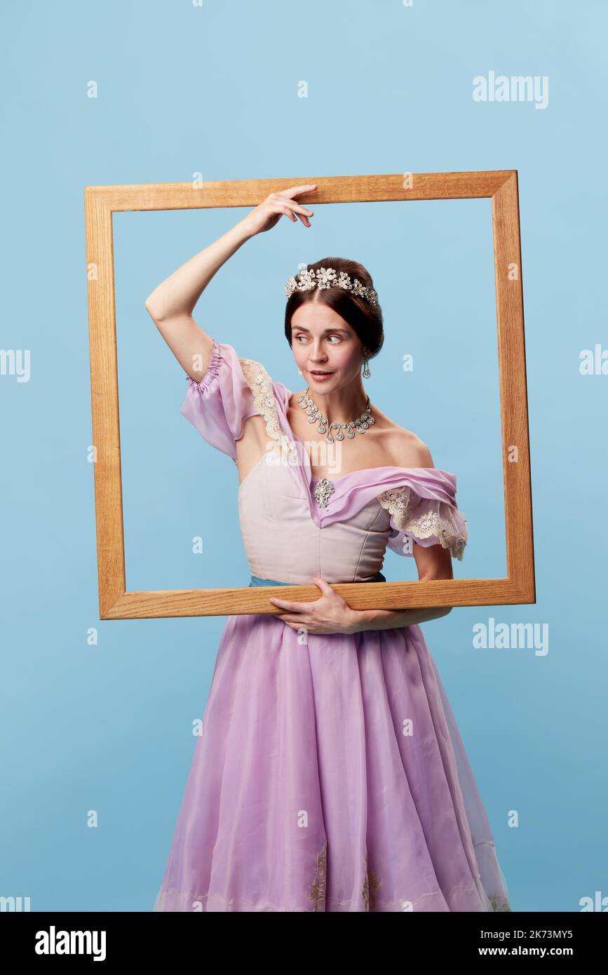 Portrait through picture frame. Young elegant woman, actress wearing ...