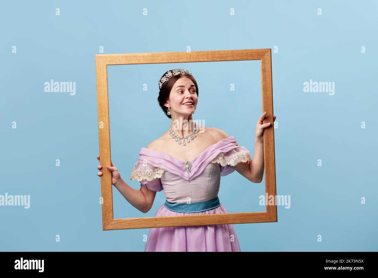 Portrait through picture frame. Young smiling woman, actress wearing ...