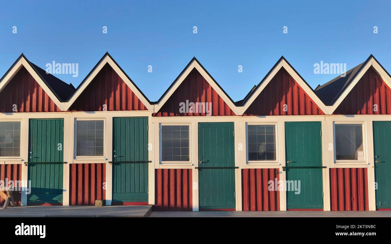 front view of beach cabins aligned under blus sky in sweden Stock Photo ...