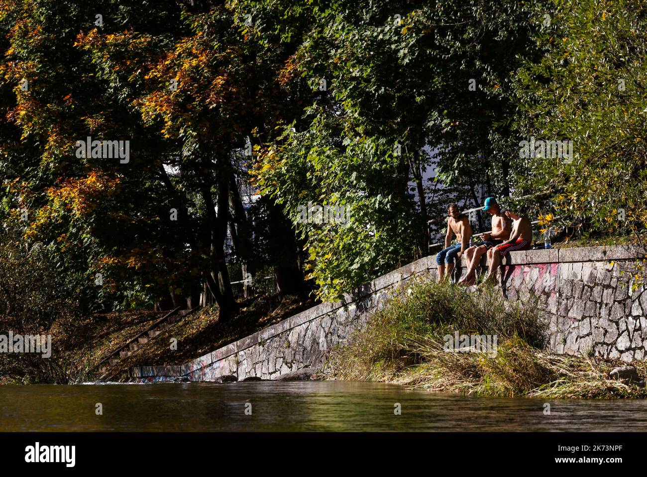 Freiburg, Germany. 17th Oct, 2022. Three men sit bare-chested in the ...