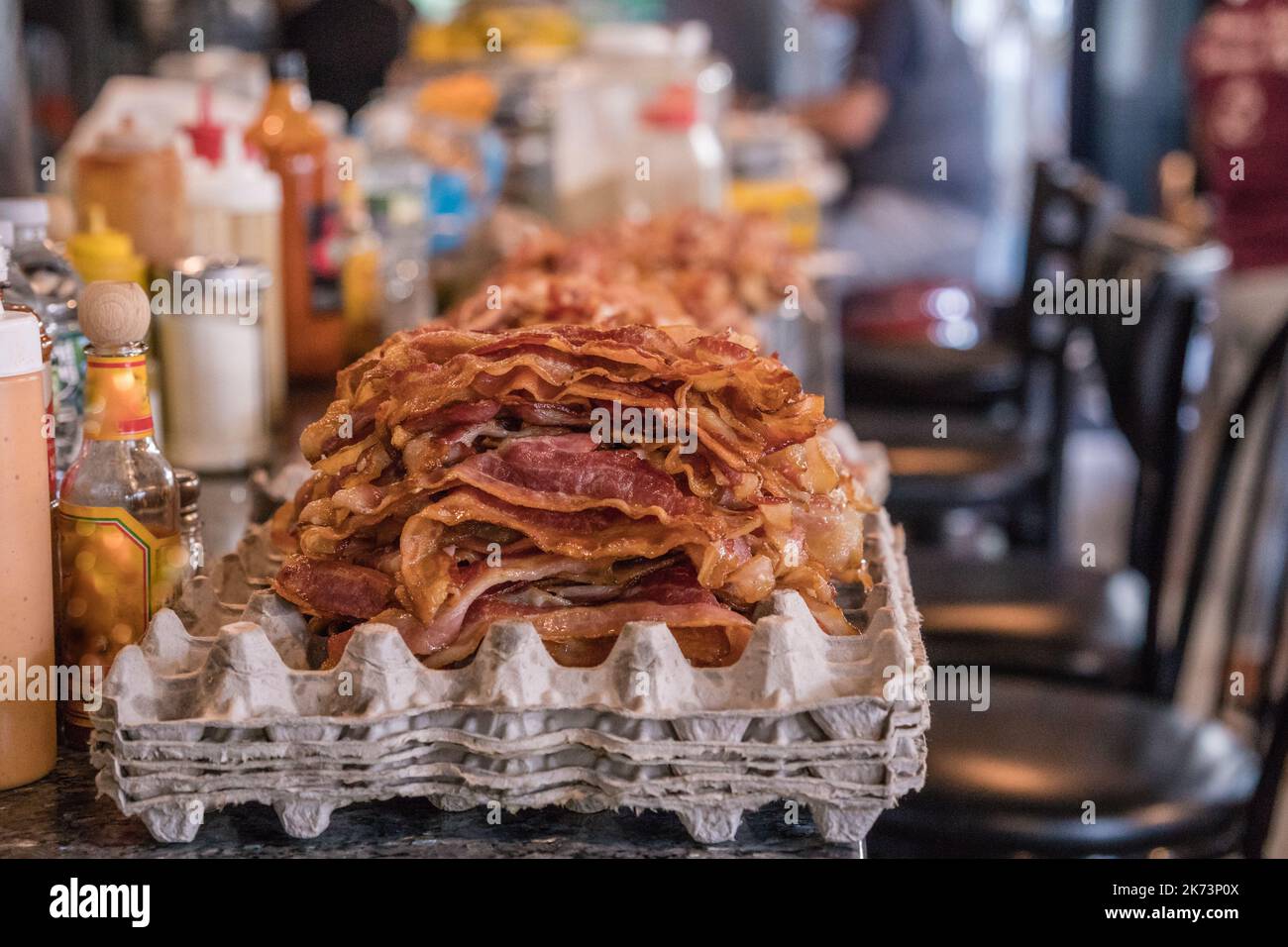 Piles of bacon on counter in local diner during breakfast prepartion ...