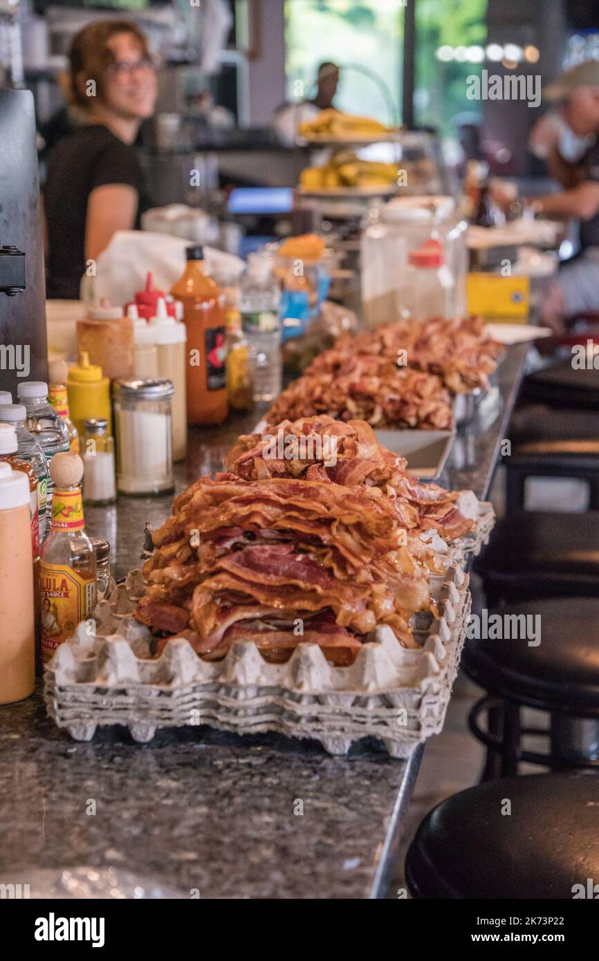 Piles of bacon on counter in local diner during breakfast prepartion ...
