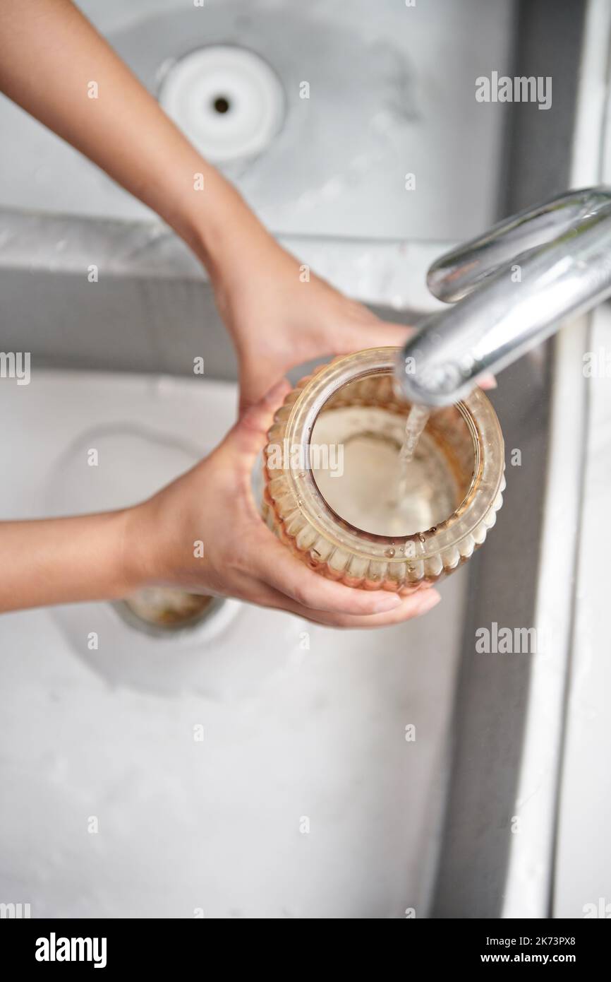 Woman changing water in glass vase, view from above Stock Photo - Alamy