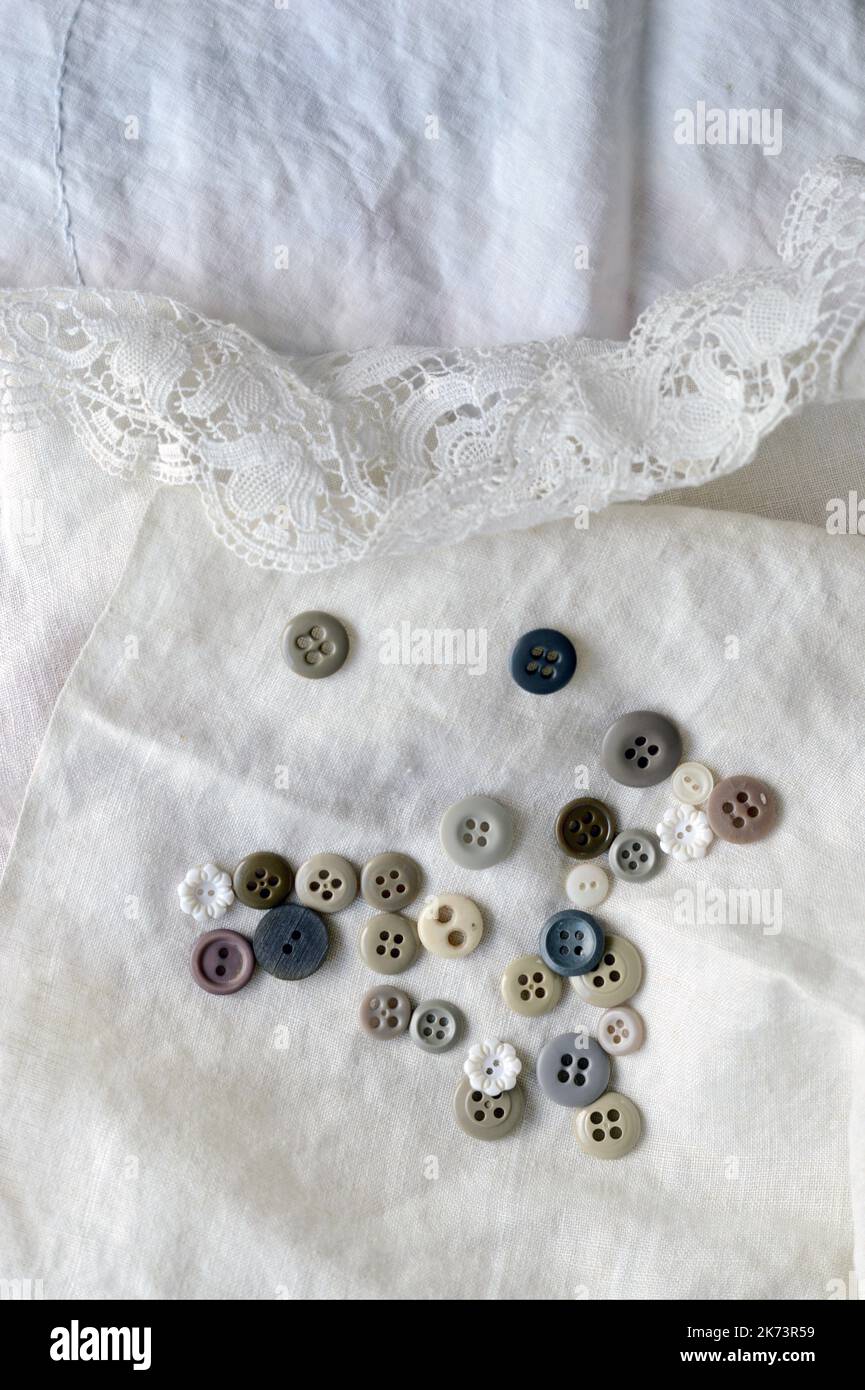 Array of vintage buttons atop vintage linen and lace fabric Stock Photo ...