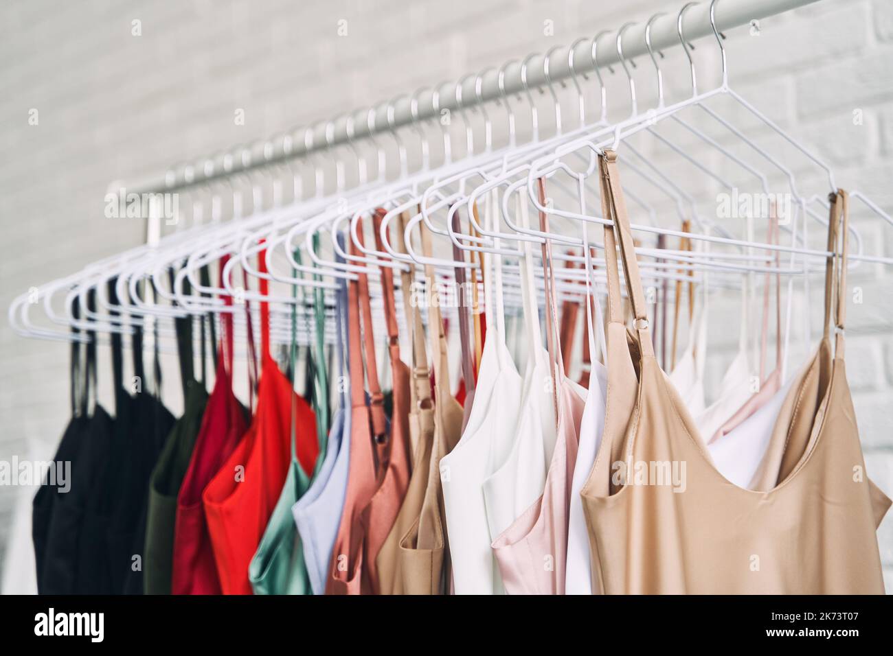 Multi-colored dresses hang on hangers in the store. Sale of women's ...