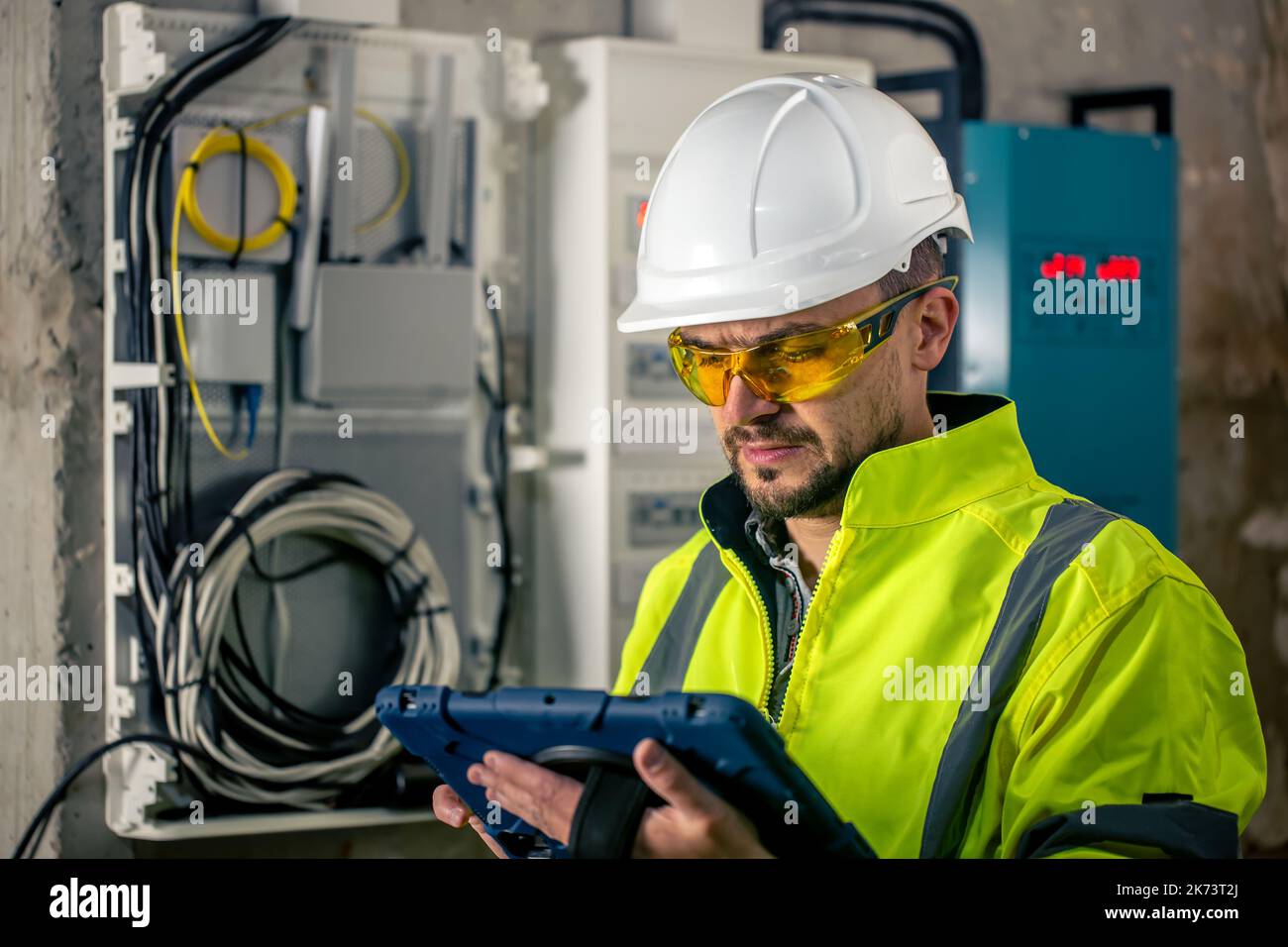 Man an electrical technician working in a switchboard with fuses, uses ...