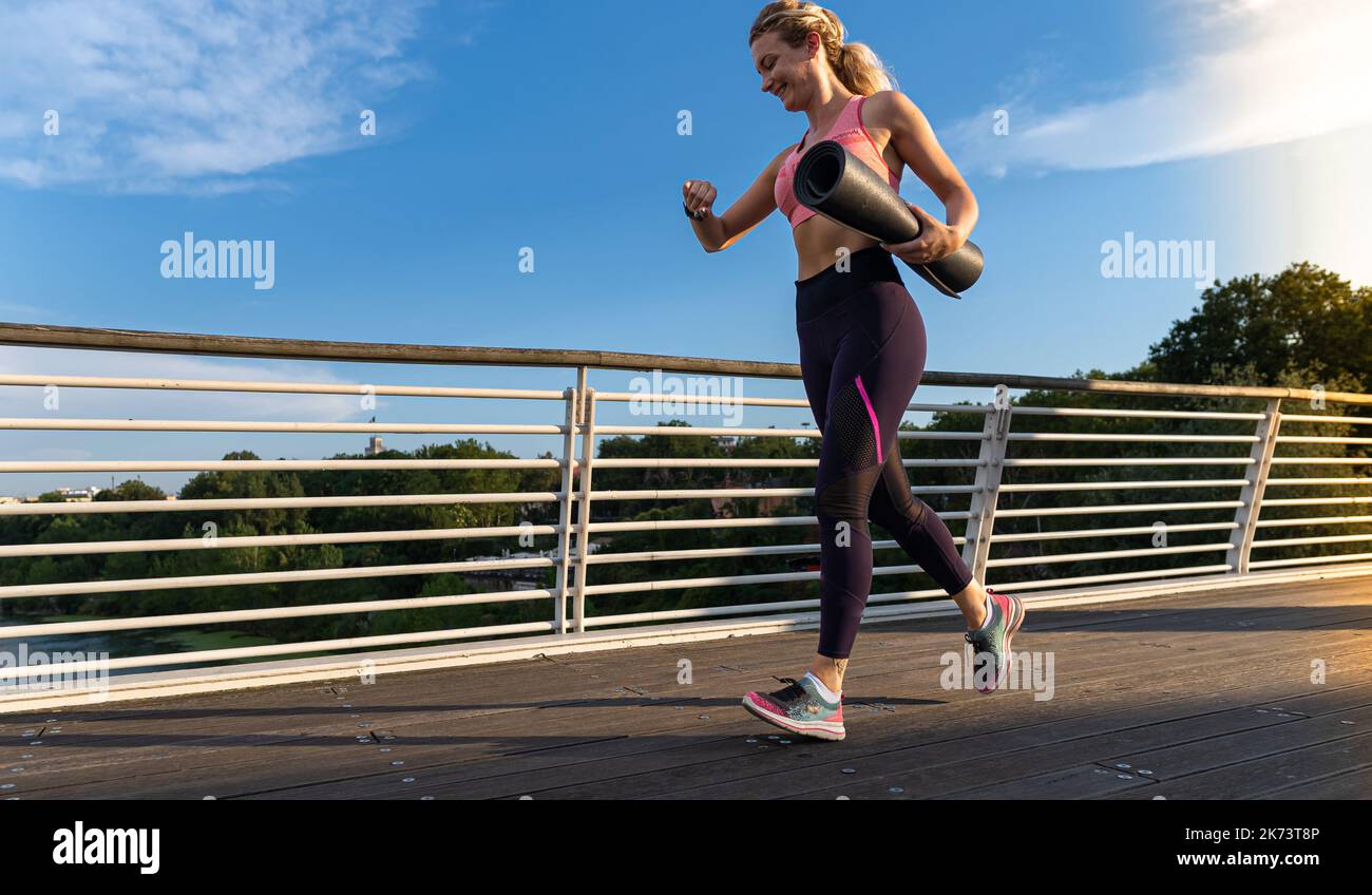 Sporty woman running watches her smartwatch in the city center Stock ...