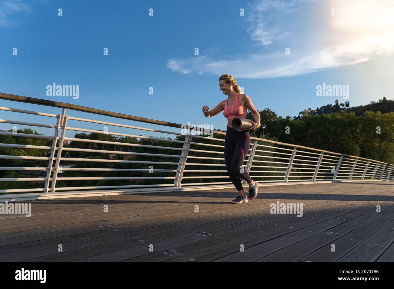 Sporty woman running watches her smartwatch in the city center Stock ...