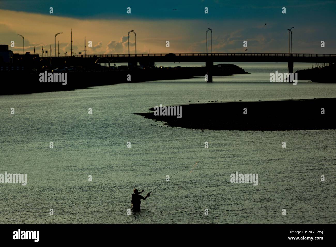 A man fishes in the Rivière Matane River in Matane near the avenue du ...