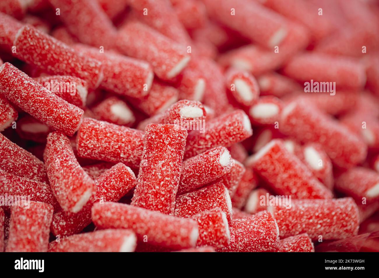Red gummies jelly candies in sugar, background Stock Photo - Alamy