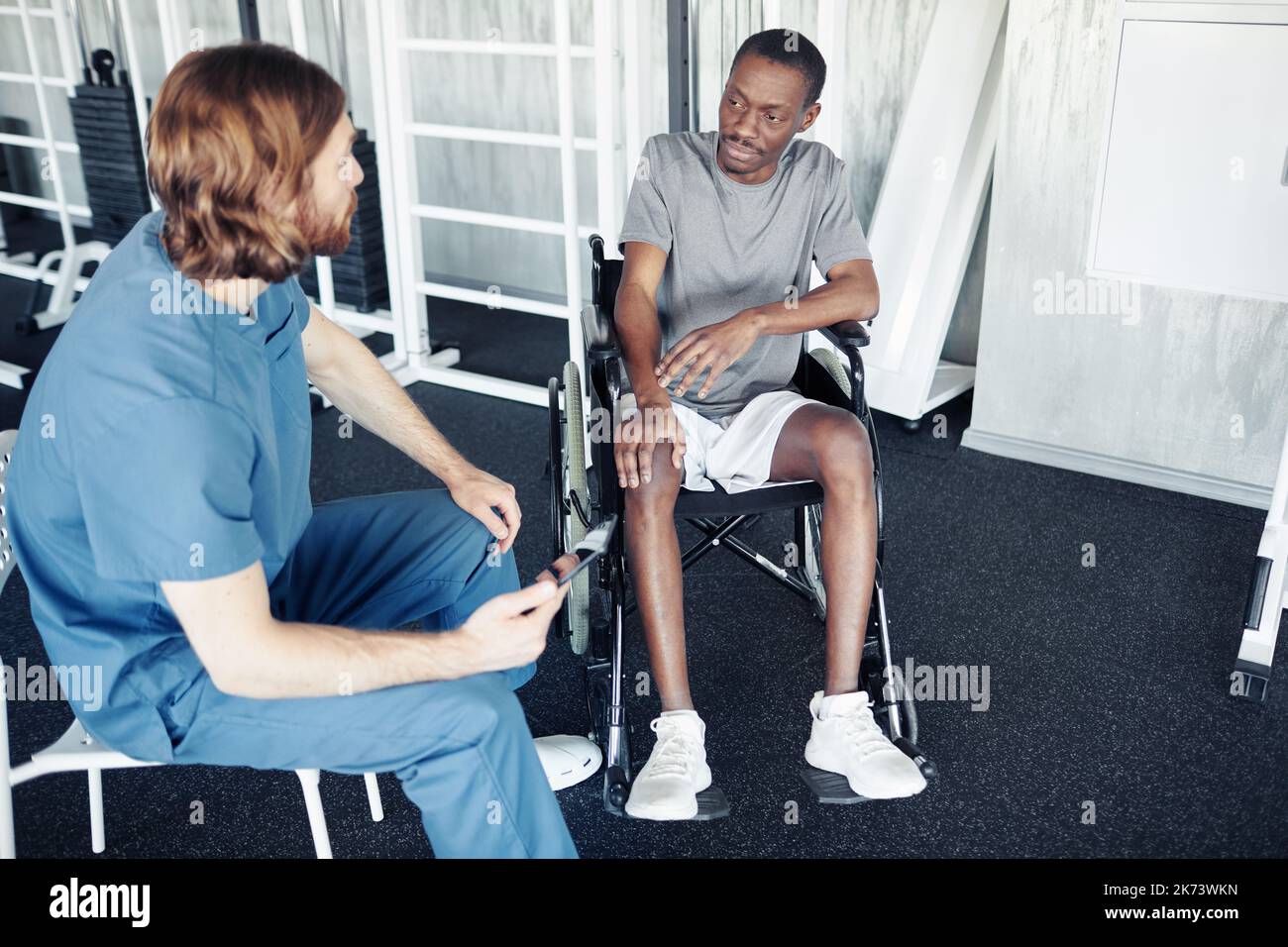 Doctor talking about treatment with patient with disability in health ...