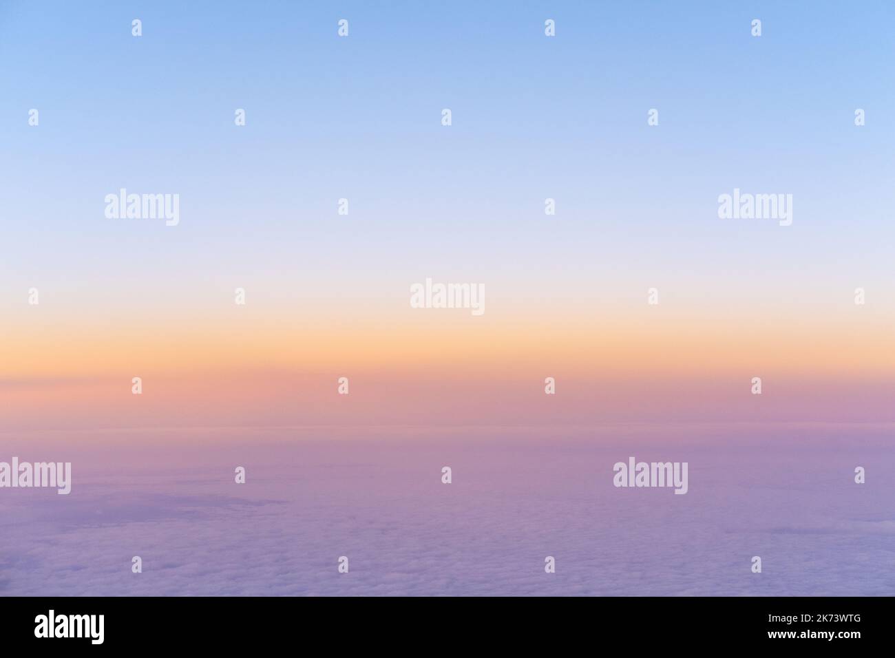 Aerial view of bright yellow sunset over pink purple dense clouds with ...